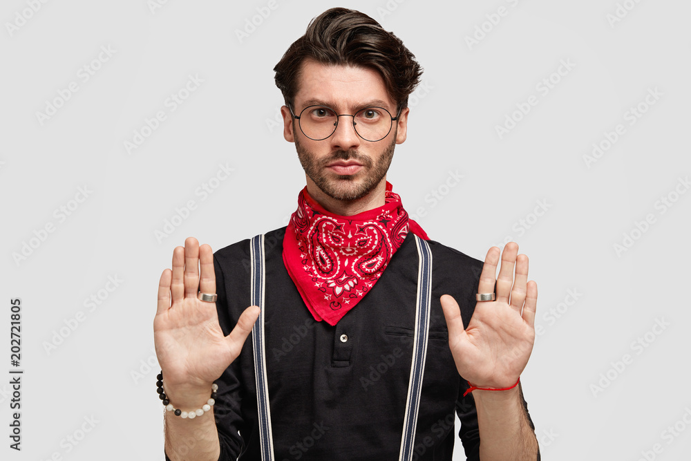 Serious bearded male shows stop gesture, denies something, wears red ...