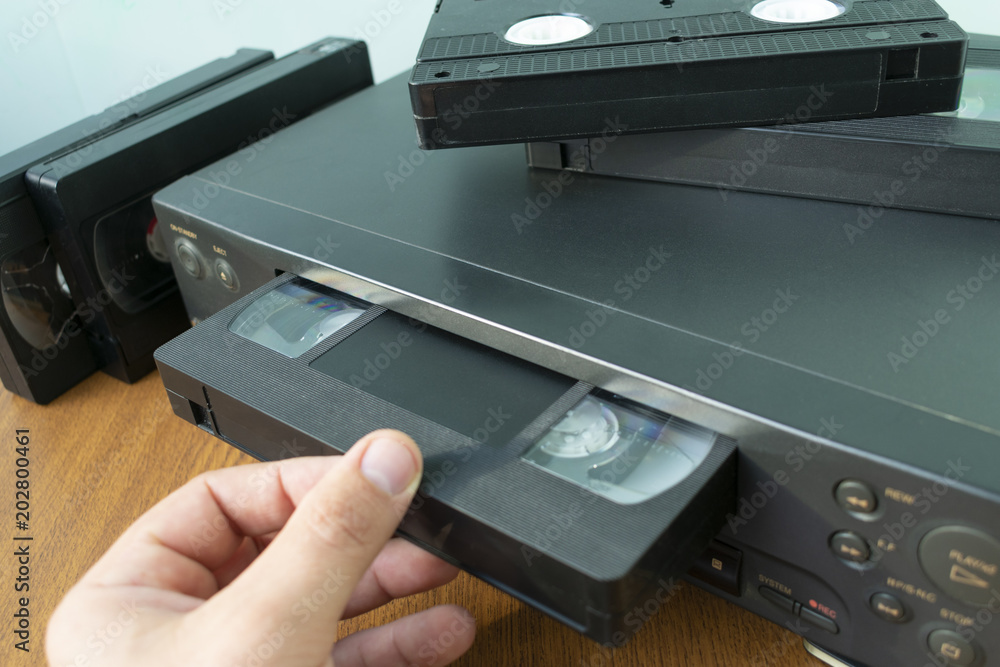 insert a videotape into a tape recorder Stock Photo | Adobe Stock