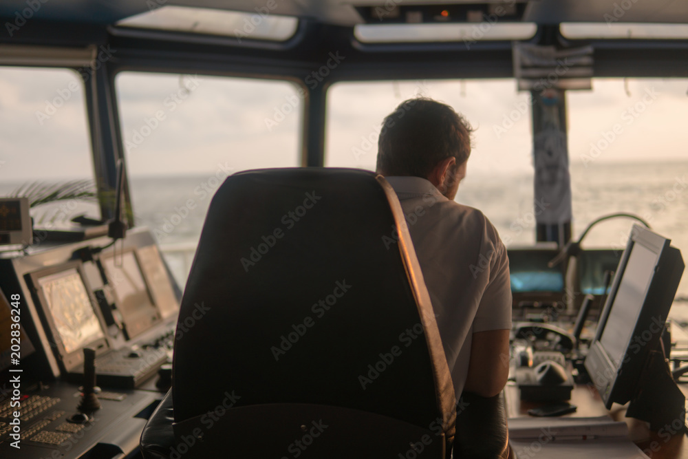 Deck navigation officer on the navigation bridge. He looks at radar ...