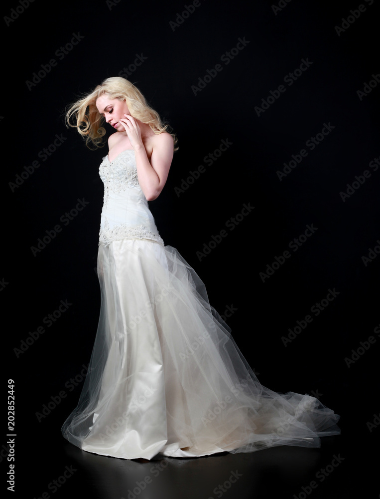 full length portrait of woman wearing white bridal gown. standing ...