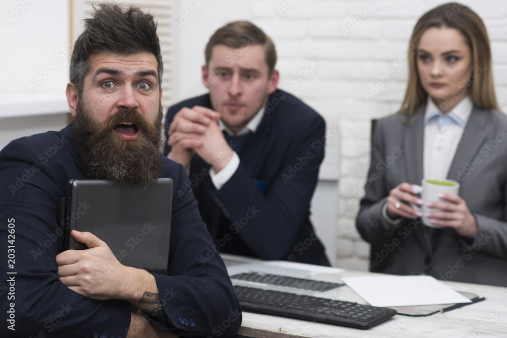 Man with beard on surprised face holds laptop, bosses, coworkers ...