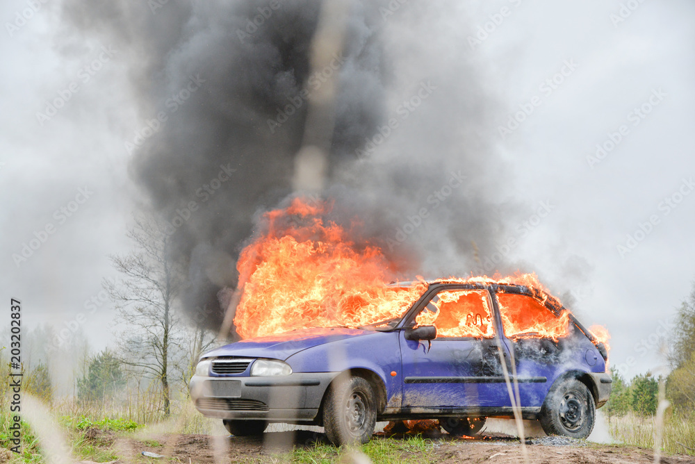 Burning and crashed car after explosion. Accident on street at ...