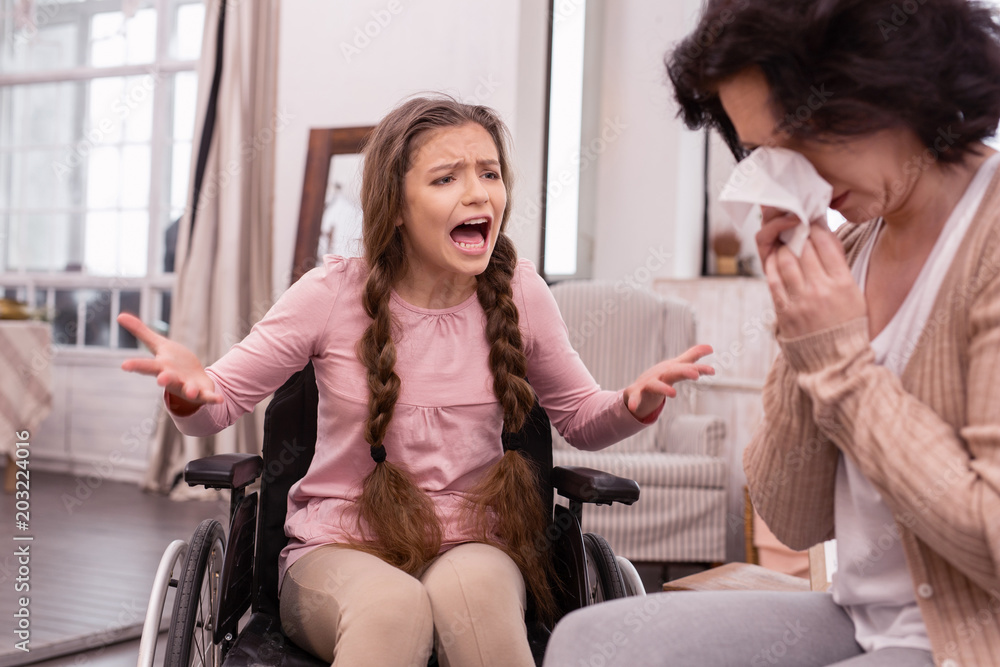Emotional breakdown. Angry immobile girl screaming while woman crying ...