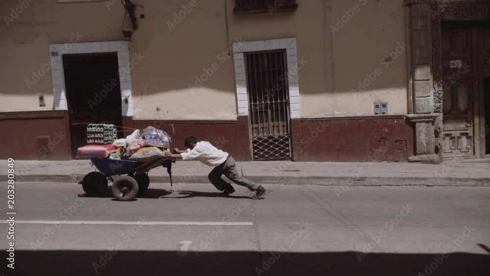 Old man pushing up the wheelbarrow loaded with groceries on the ...