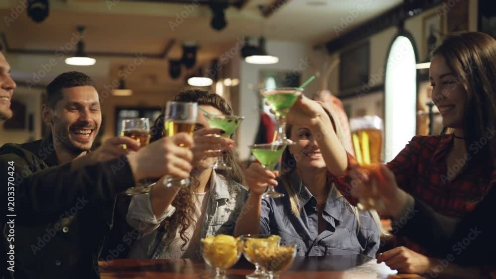Students are celebrating end of academic session in modern pub. They ...