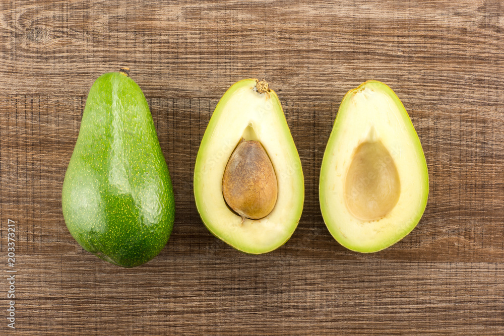 Green smooth avocado collection table top isolated on brown wood ...