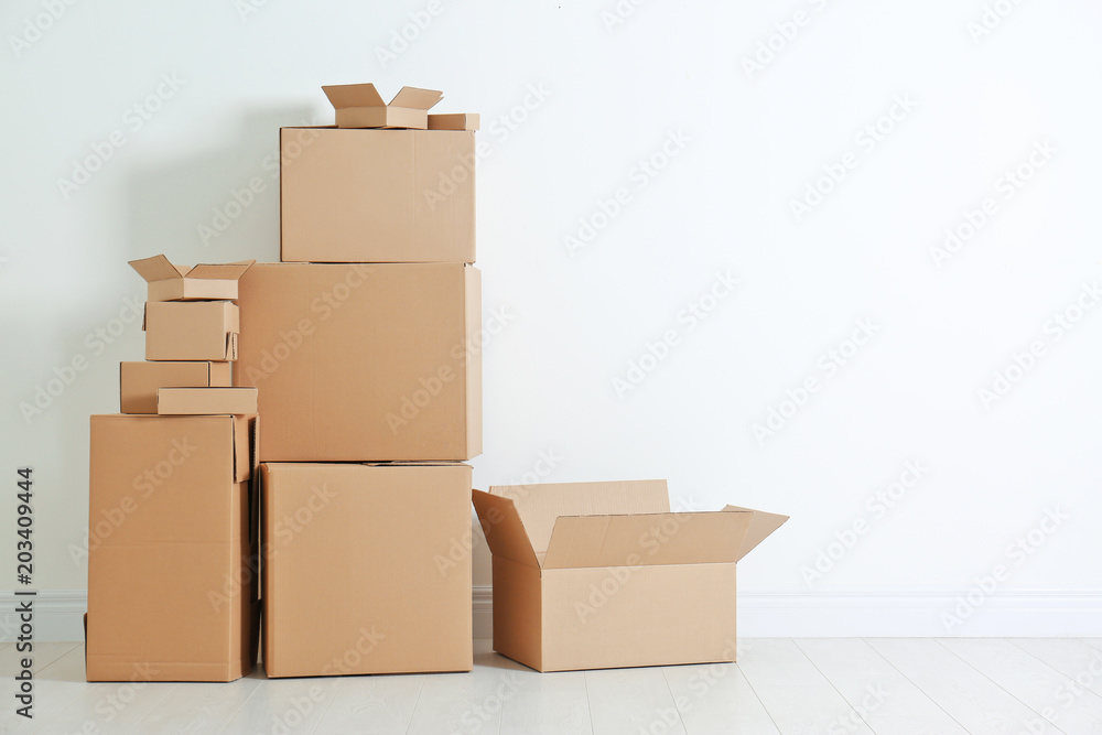 Cardboard boxes on floor near white wall Stock Photo | Adobe Stock