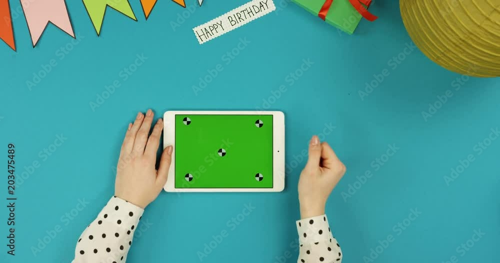 Top view on the white horizontal tablet device lying on the blue table ...