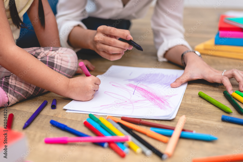 Closed up hands of mom teaching little children to drawing cartoon in ...