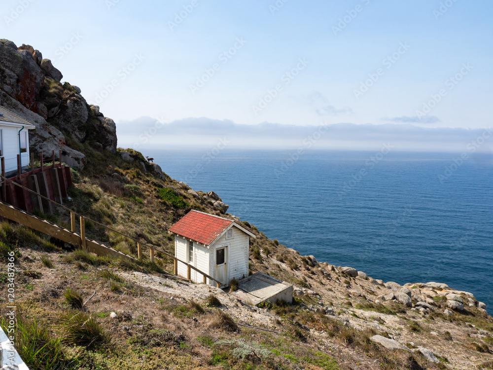 Deer and old outhouse shack near Visitor's Center along rocky cliff ...