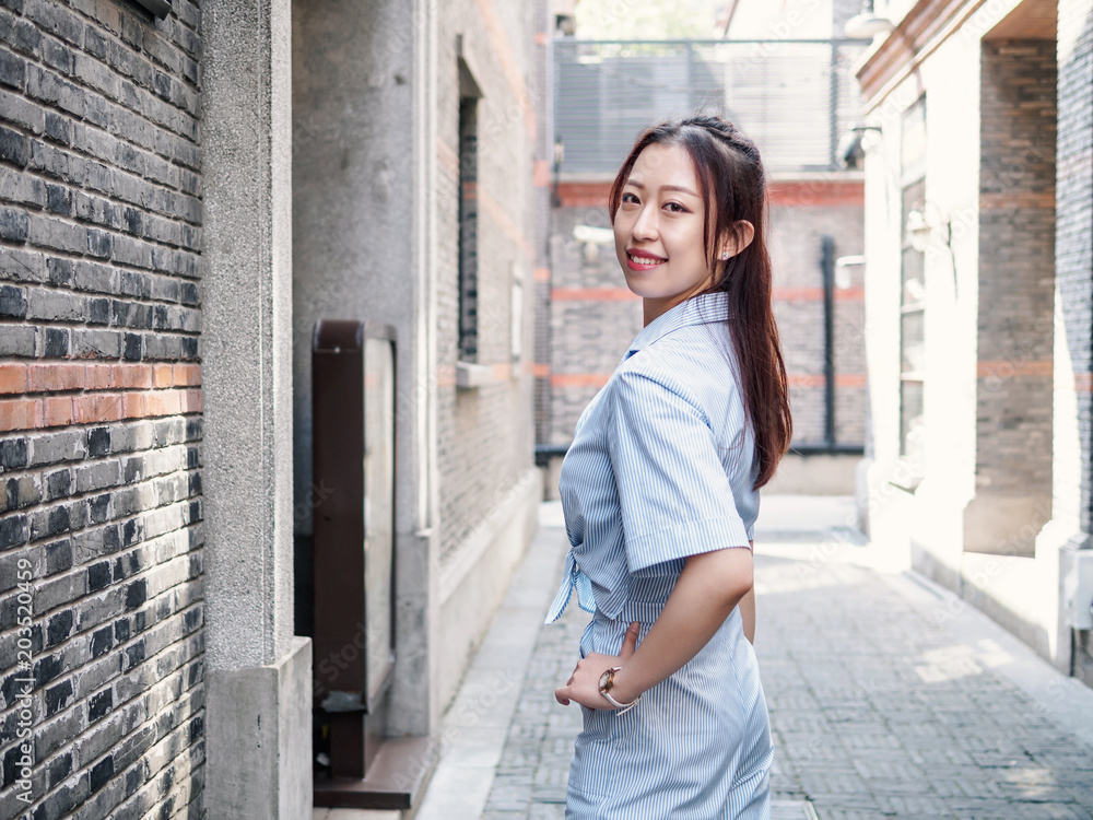 Portrait of beautiful young Chinese woman posing in Shanghai Xintiandi ...