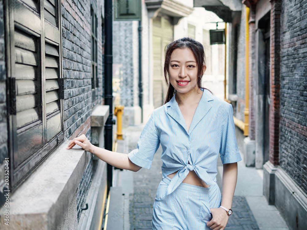 Portrait of beautiful young Chinese woman posing in Shanghai Xintiandi ...