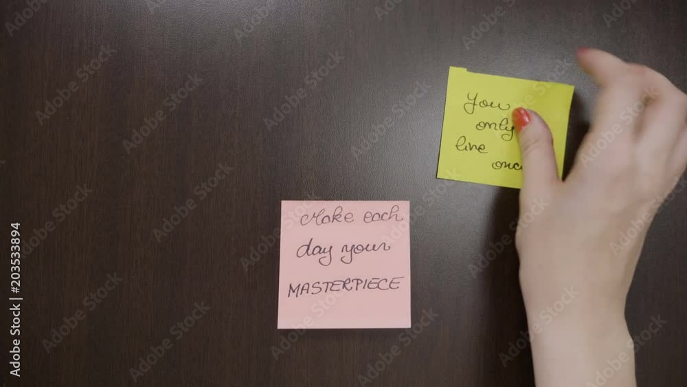 Top view of female hands sticking handwritten post it notes that ...