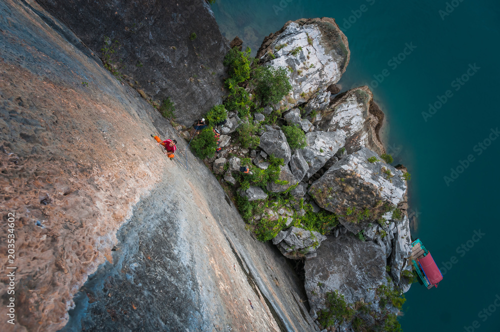 Man rock climbing on limestone rock, overhead view, Ha Long Bay ...