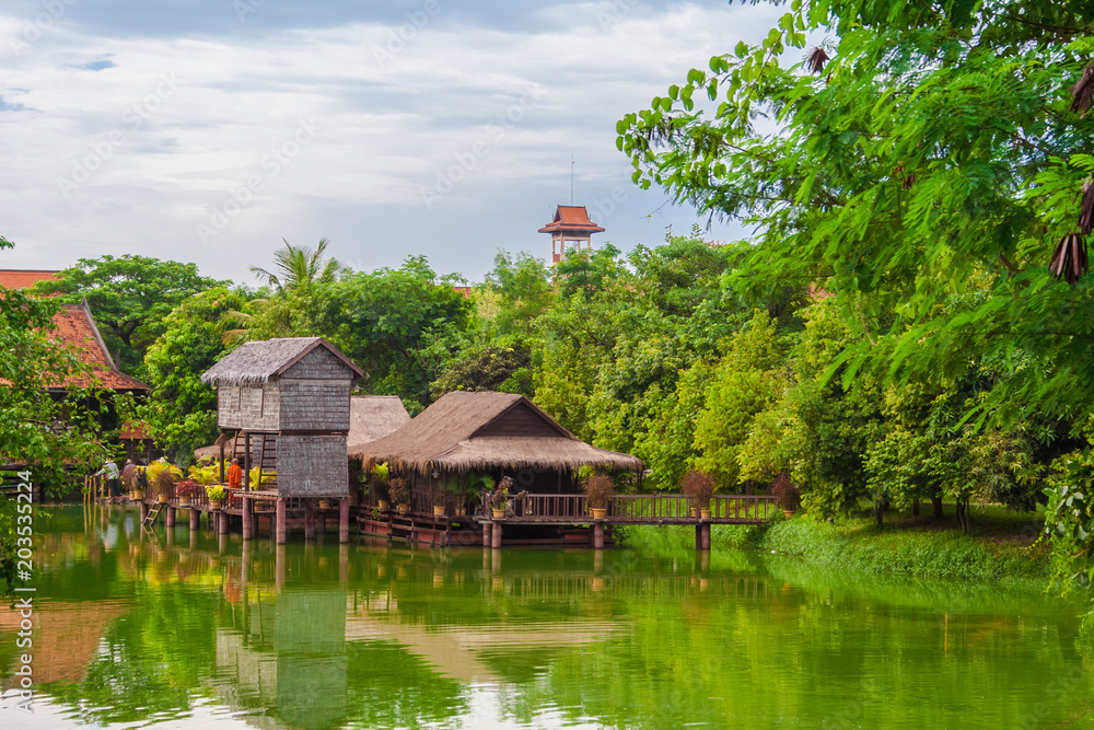 A traditional wooden Khmer house on stilts reflected by the water of ...