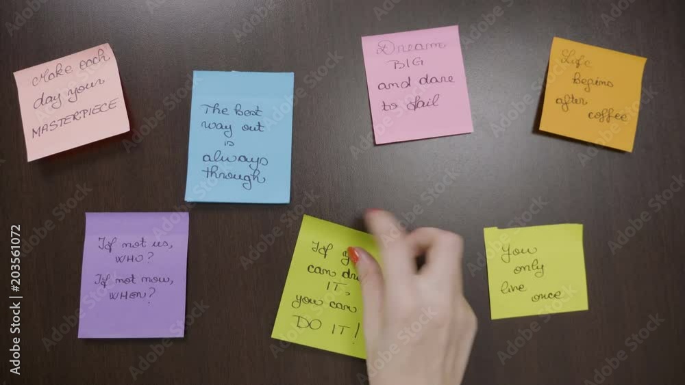 Top view of girl hands adding to handwritten sticky post it notes to ...