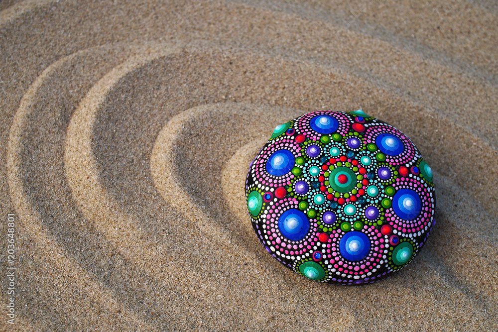 hand painted mandala rock on sand Stock Photo | Adobe Stock