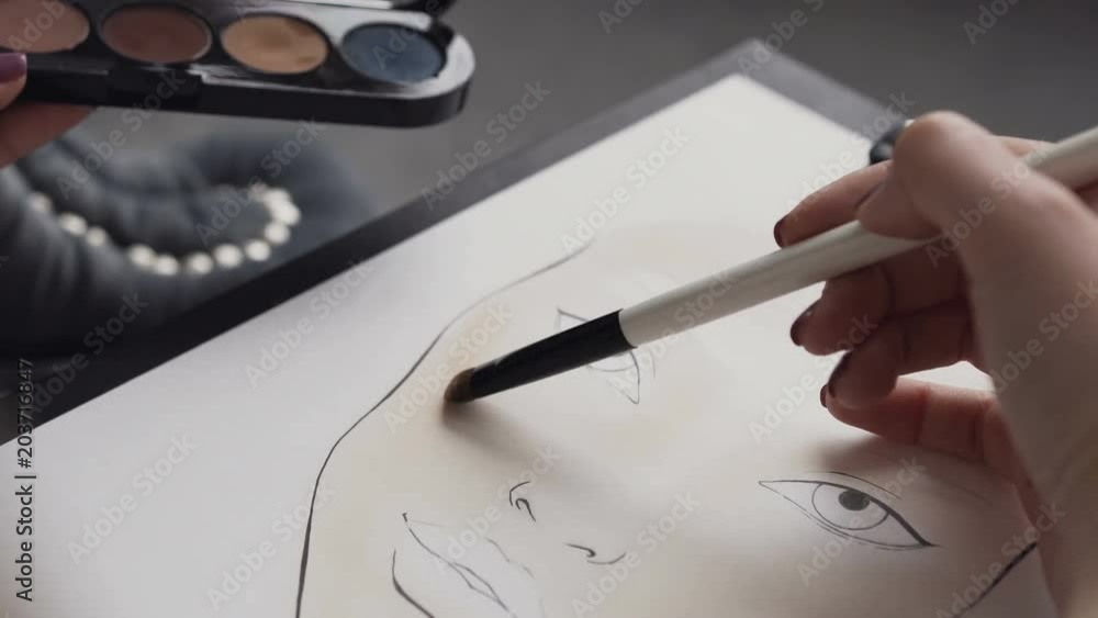 Stockvideo A young woman make-up artist learns to apply make-up using ...