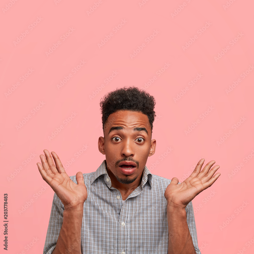 I am not privy to this! Puzzled scared mixed race male model gestures ...