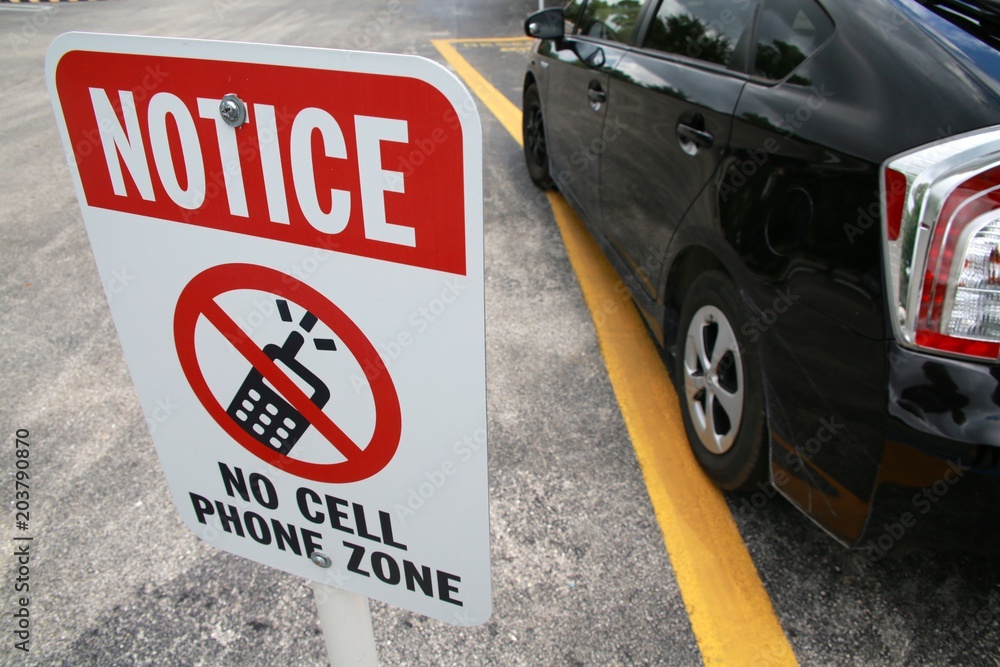 Red Black and White Notice No Cell Phone Zone Sign with a Black 4-Door ...