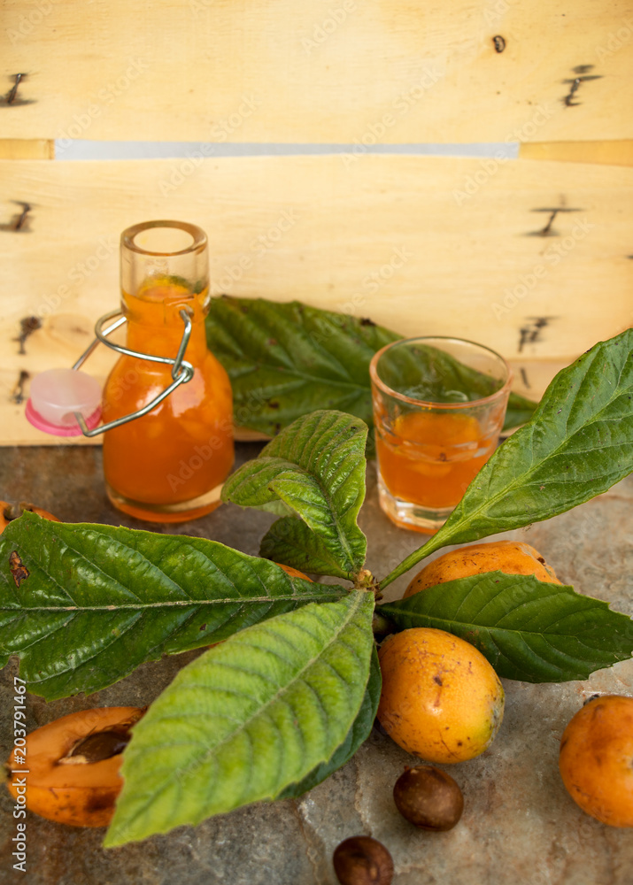 Mispeln mit Kernen, Blättern und einem Fläschchen Likör Stock Photo ...