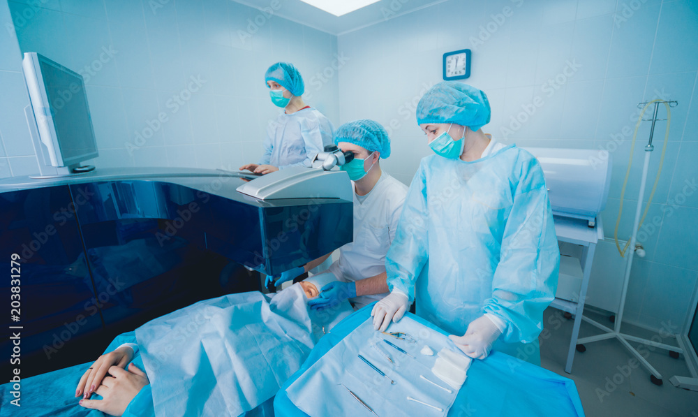 Laser vision correction. A patient and team of surgeons in the ...