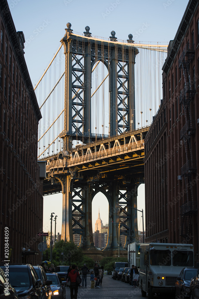 Brooklyn bridge seen from a narrow alley enclosed by two brick ...