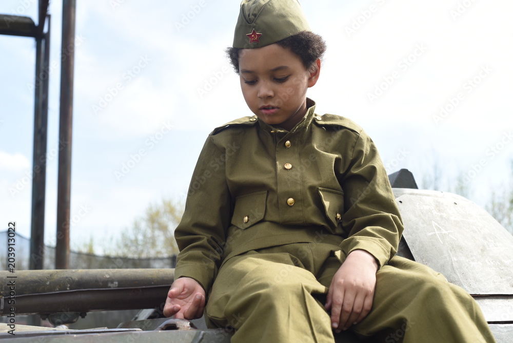 Boy in the military uniform on the tank of time of Second World War ...