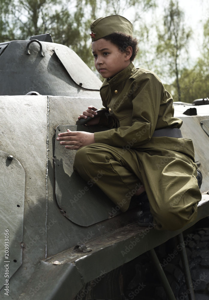 Boy in the military uniform on the tank of time of Second World War ...