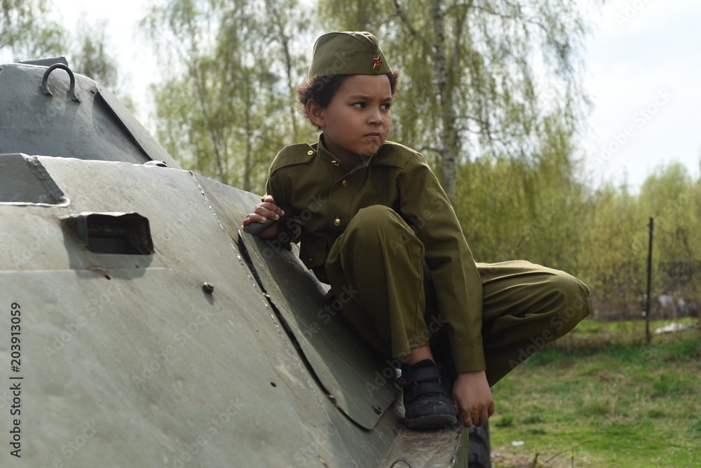 Boy in the military uniform on the tank of time of Second World War ...