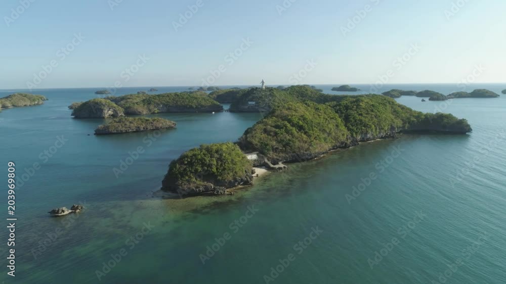 Small islands in Hundred Islands National Park with statue of Jesus ...