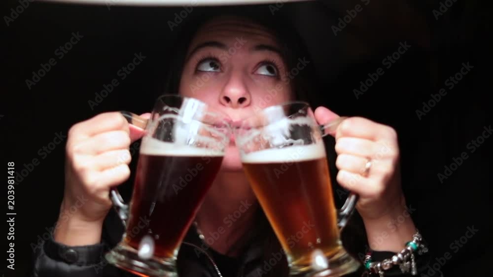 Woman acting silly celebrating with draft beers toasting herself ...