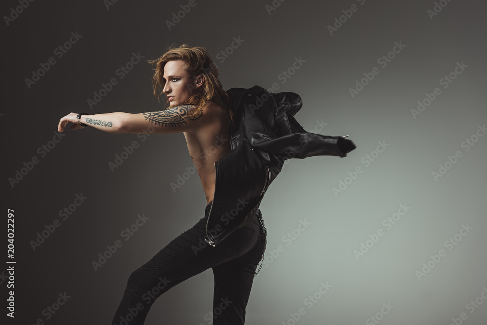 tattooed rocker man with long hair in black leather jacket, isolated on ...