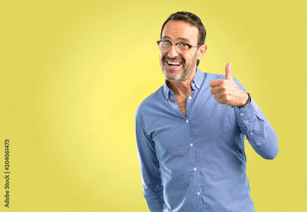Handsome middle age man smiling broadly showing thumbs up gesture to ...