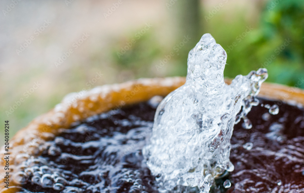 Water in small fountain flowing up high from pipe and form interesting ...