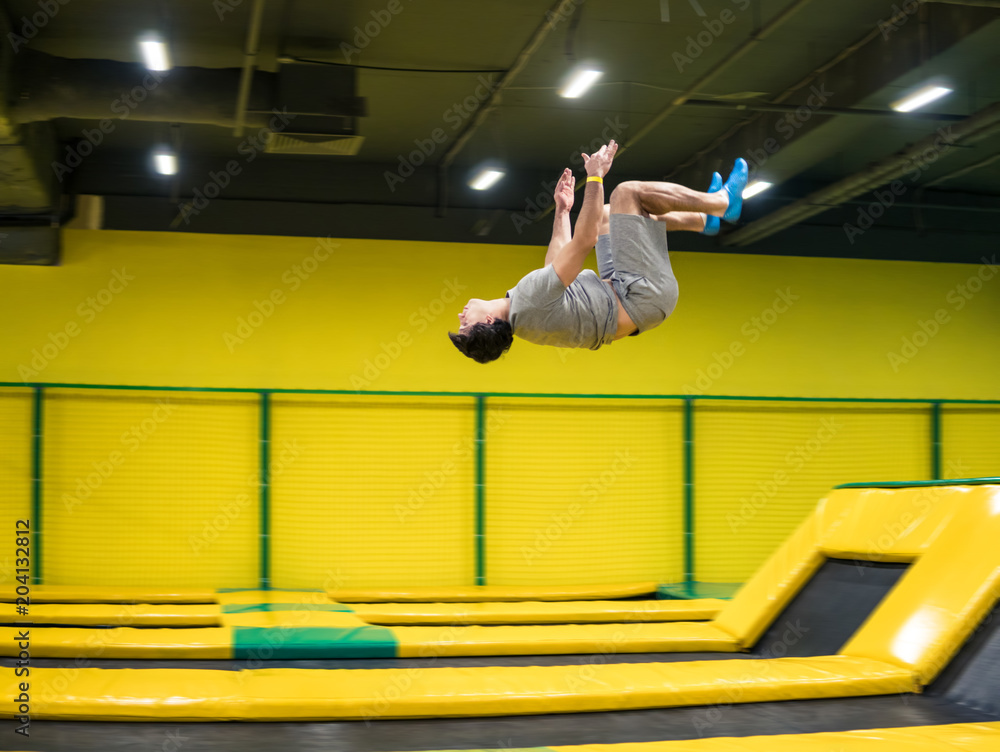 trampoline jumper performs complex acrobatic exercises and somersault ...