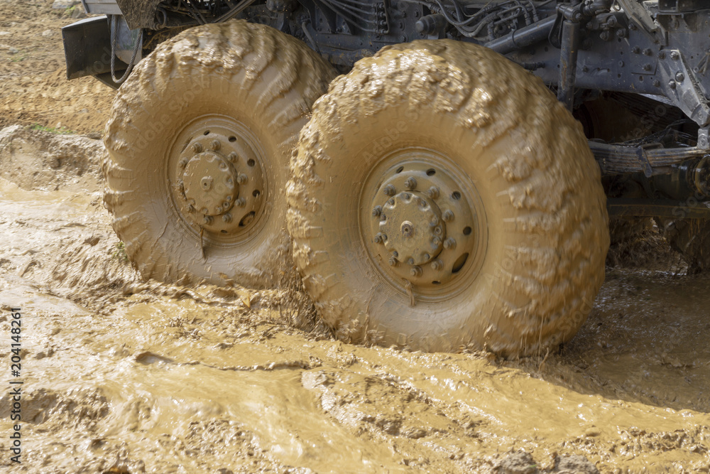 big wheels in the mud. The large wheels of a truck stuck in the mud ...