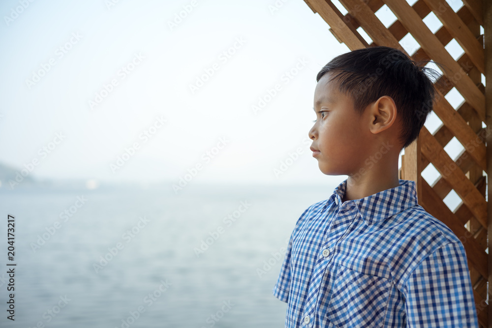 The boy stand at the waterside overlooking view at Bang Phra reservoir ...