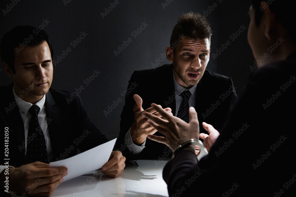 Foto de Criminal man being interviewed in interrogation room after ...