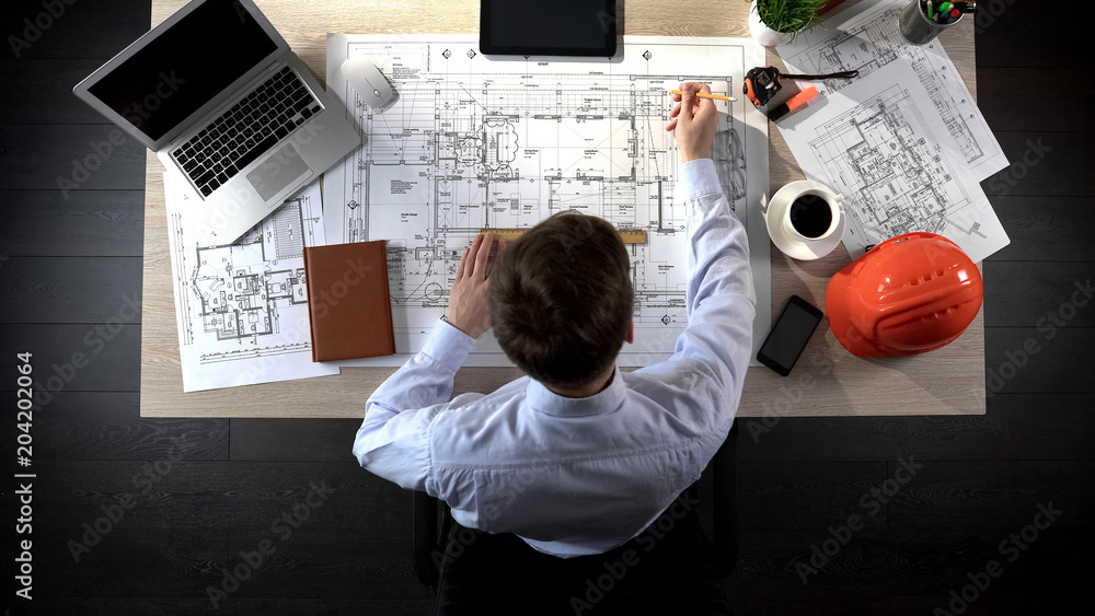 Engineer drawing plan of building, safety engineering, office location ...