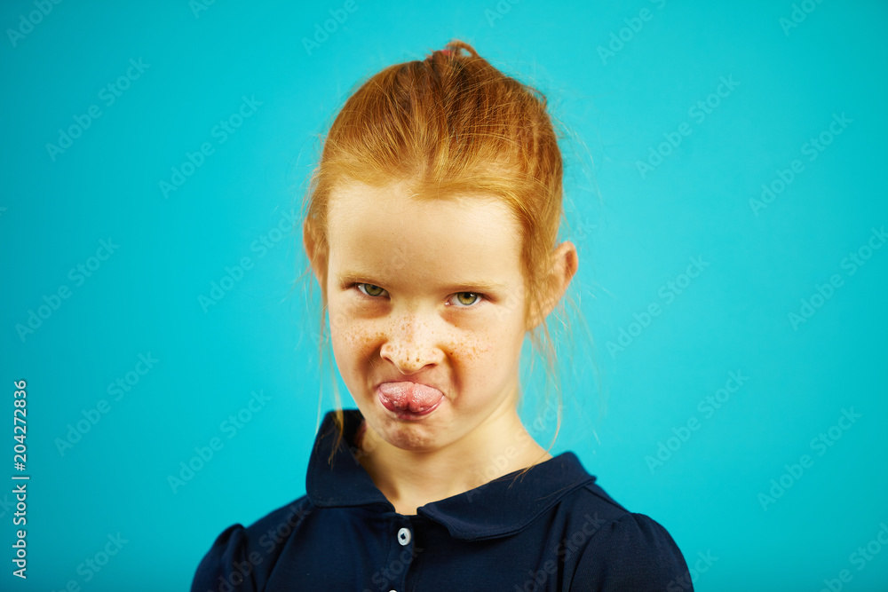 Angry girl with capricious expression of resentment shows tongue, has ...