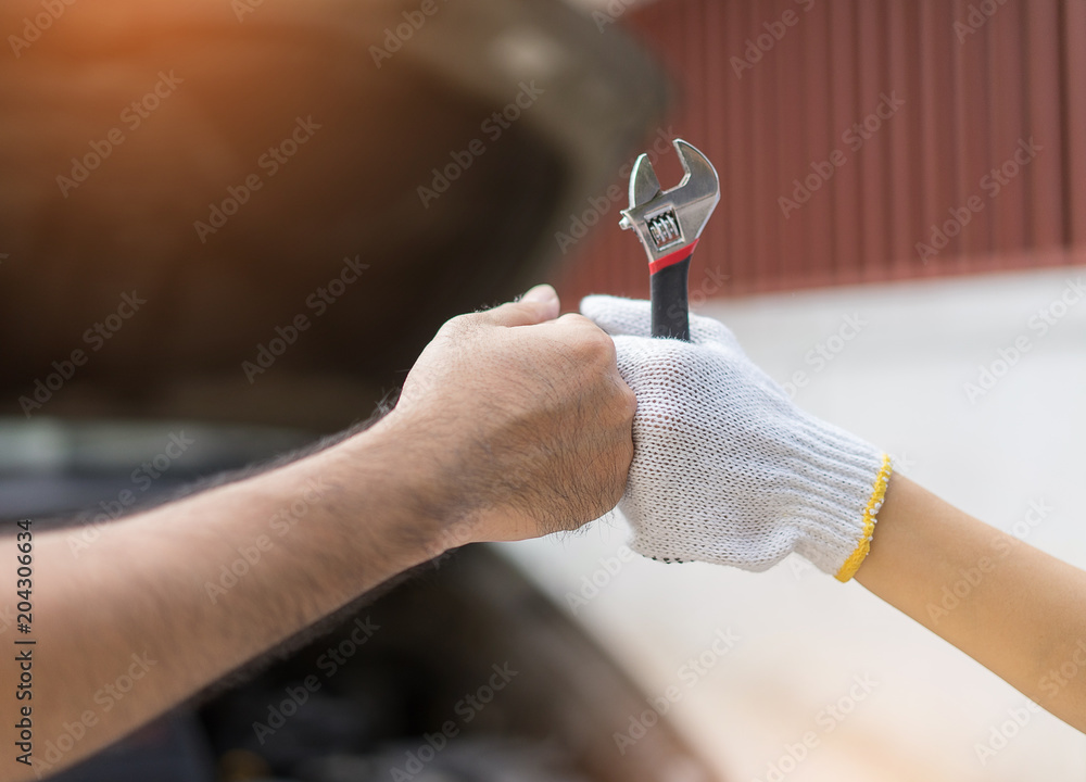 Mechanic hand checking and fixing a broken car in garage.hand of ...