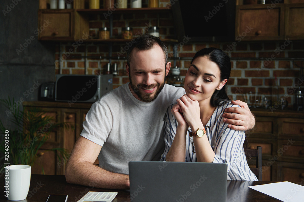 smiling young couple making video call with laptop at kitchen Stock ...