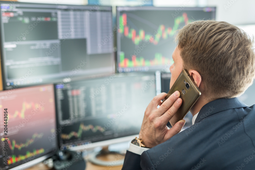 Over the shoulder view of and stock broker trading online while ...