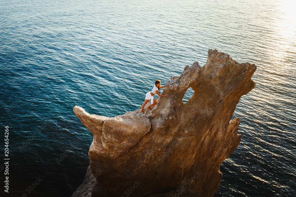 A high cliff in the form of a natural bed is high above the sea. The ...