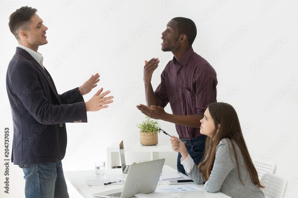 Diverse african and caucasian colleagues disputing at group meeting ...