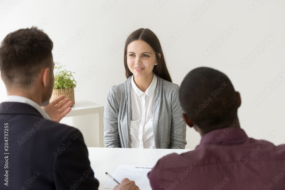 Confident female applicant smiling at job interview with diverse hr ...