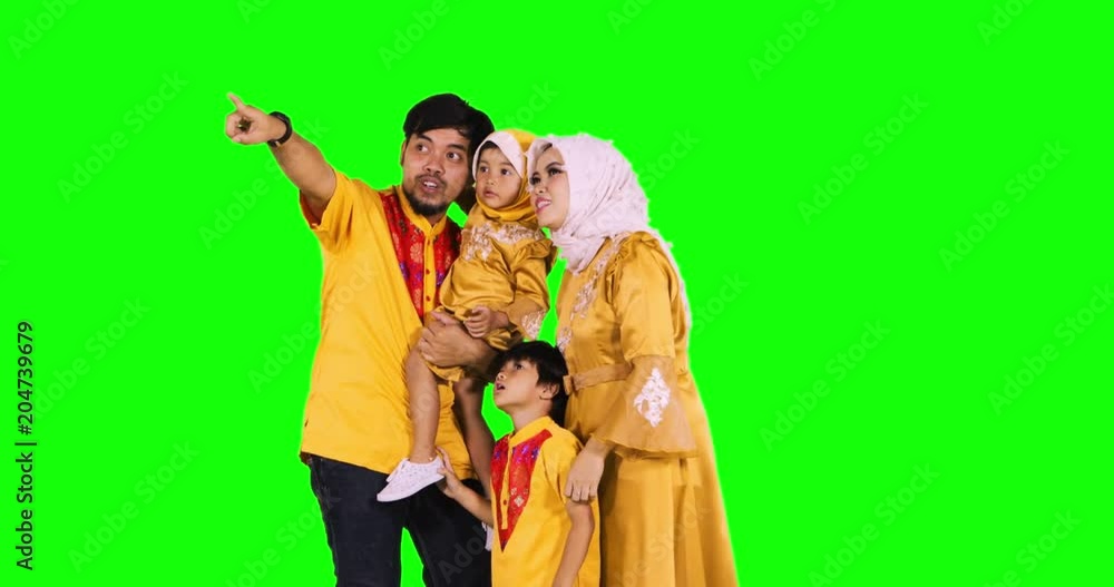 Two young muslim parents and their children standing in the studio ...