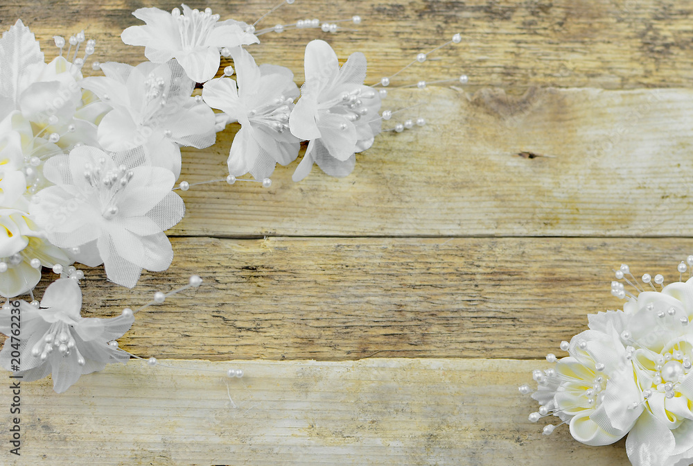 White and ivory silk flowers on a rustic wooden white washed background ...