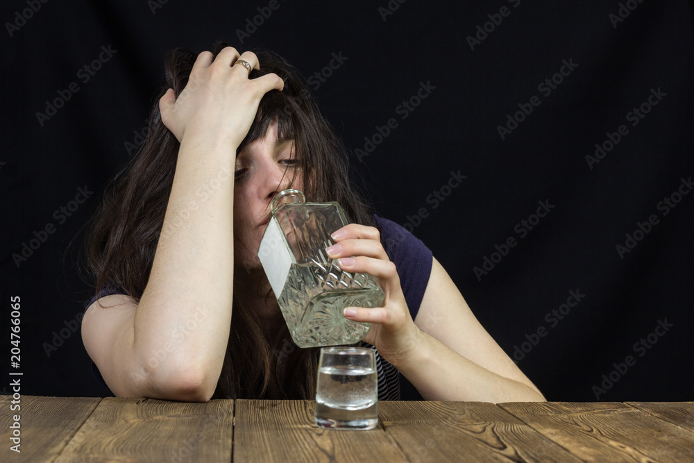 drunk girl uses alcohol on a black background, female alcoholism Stock ...